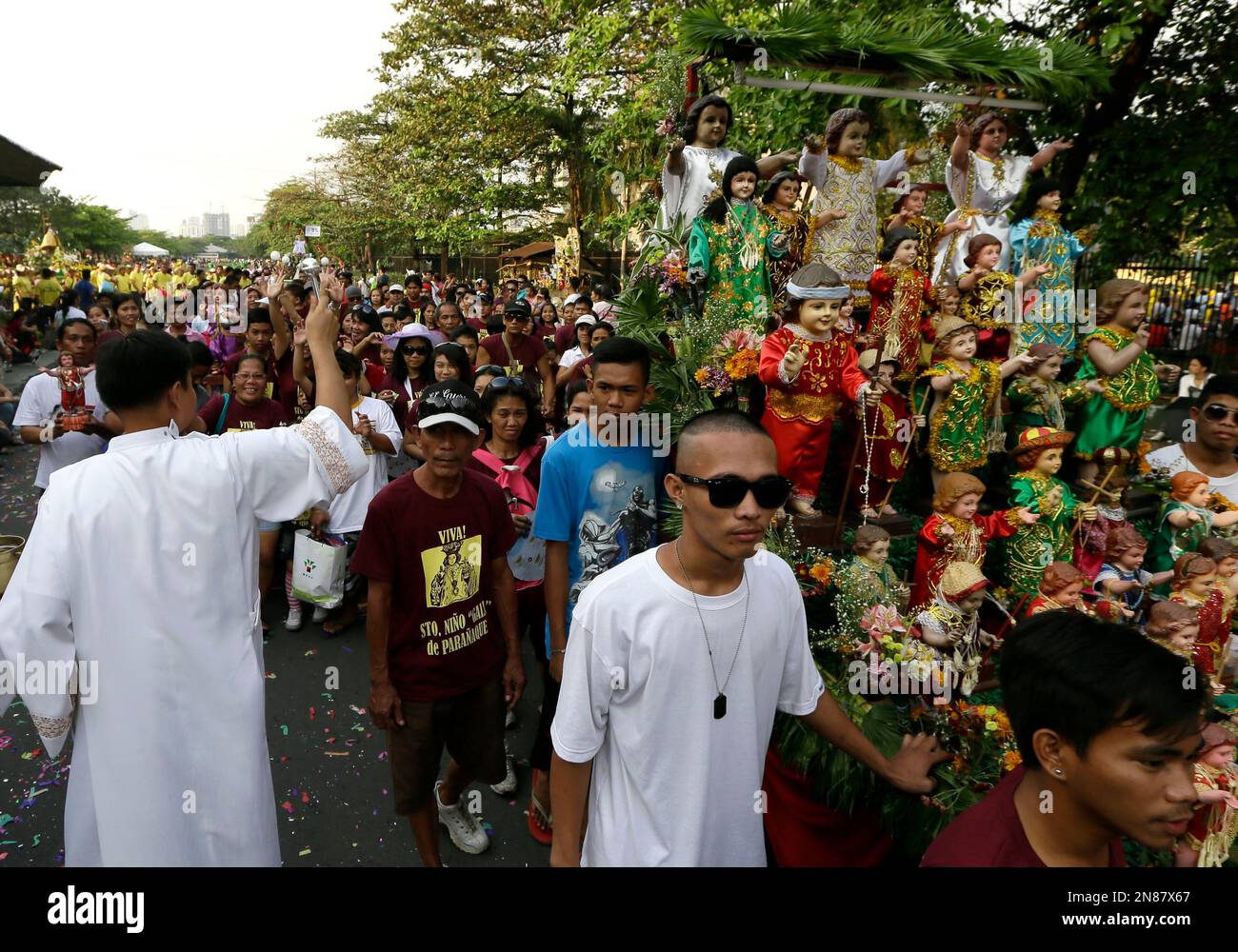 A Roman Catholic priest sprinkles Holy Water at images of the Infant ...