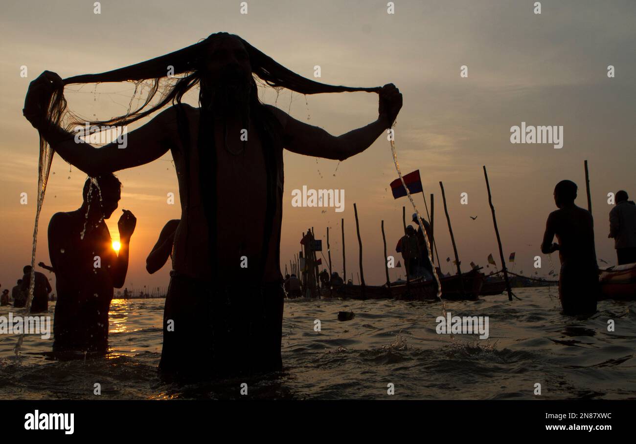 A Hindu devotee takes a holy bath at "Sangam," the meeting point of ...
