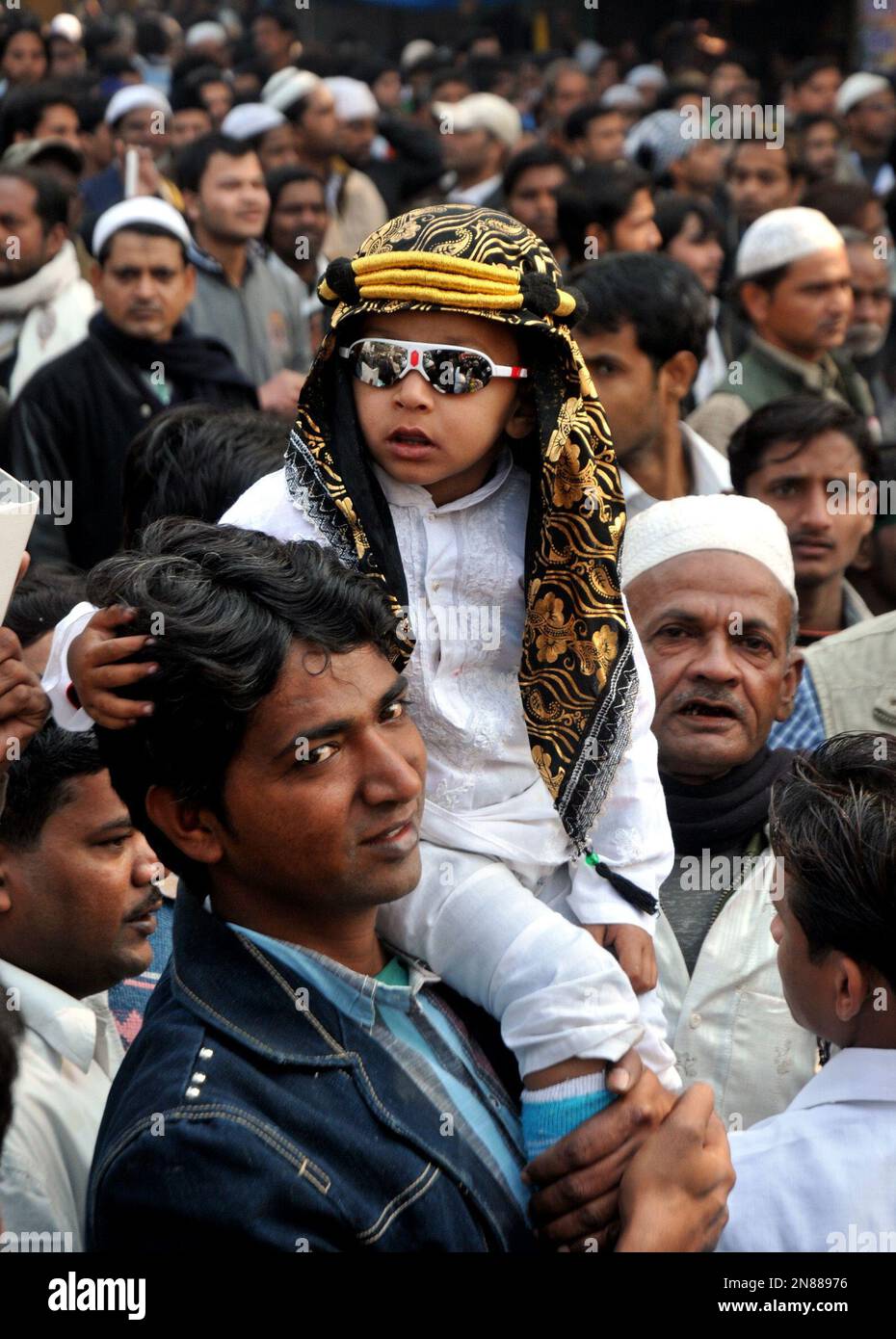 An Indian Muslim carries a child on his shoulder and participates in a ...