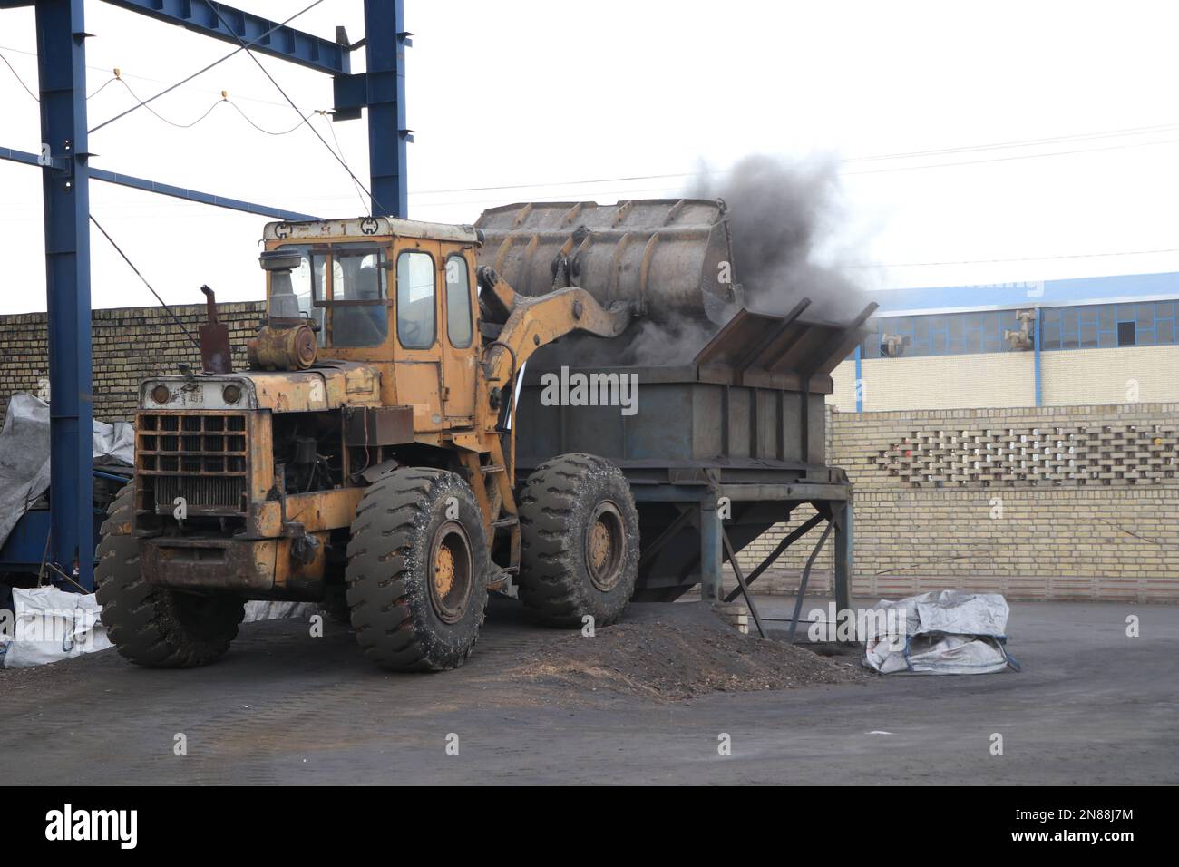 An excavator digging the ground and loading black dust for construction ...