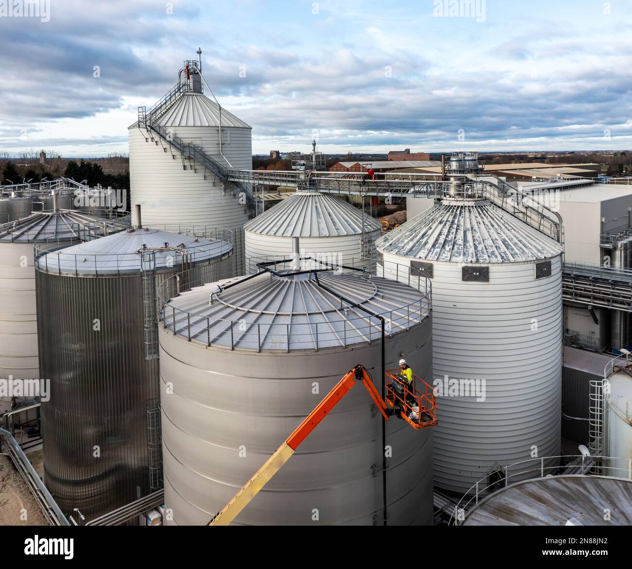 A male worker on an elevated work platform or cherry picker working at ...