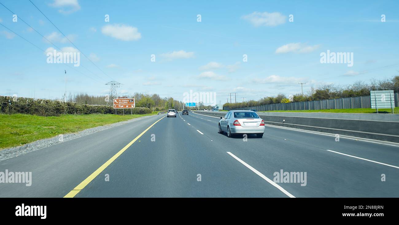Rear view of cars driving on motorway, Ireland. Road with metal safety ...