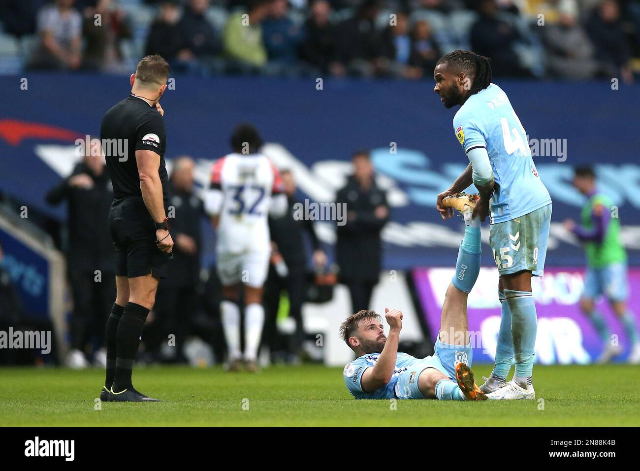 Coventry City's Matthew Godden (centre) receives treatment for cramp ...