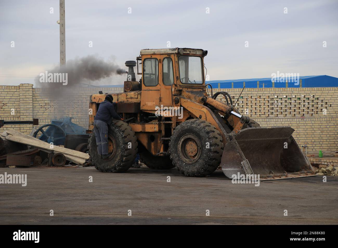 An excavator digging the ground and loading black dust for construction ...