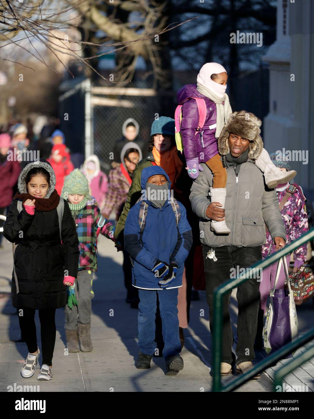 Children and adults bundled up against the cold arrive to school in New ...