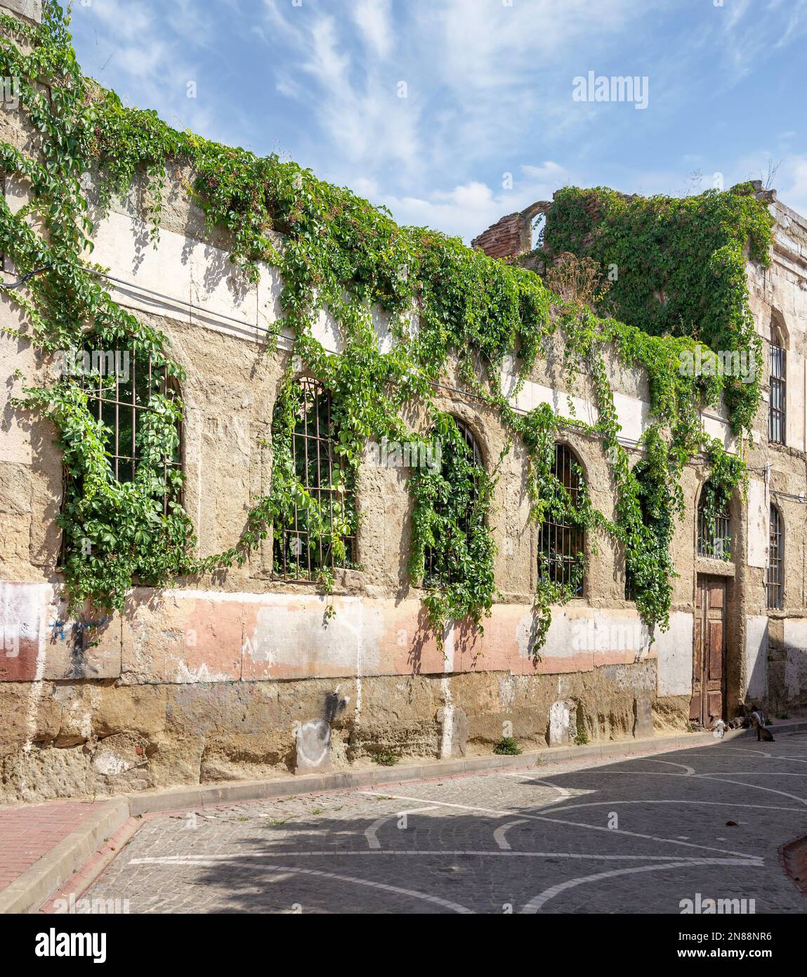 Exterior of old abandoned building, with weathered stone wall, and ...