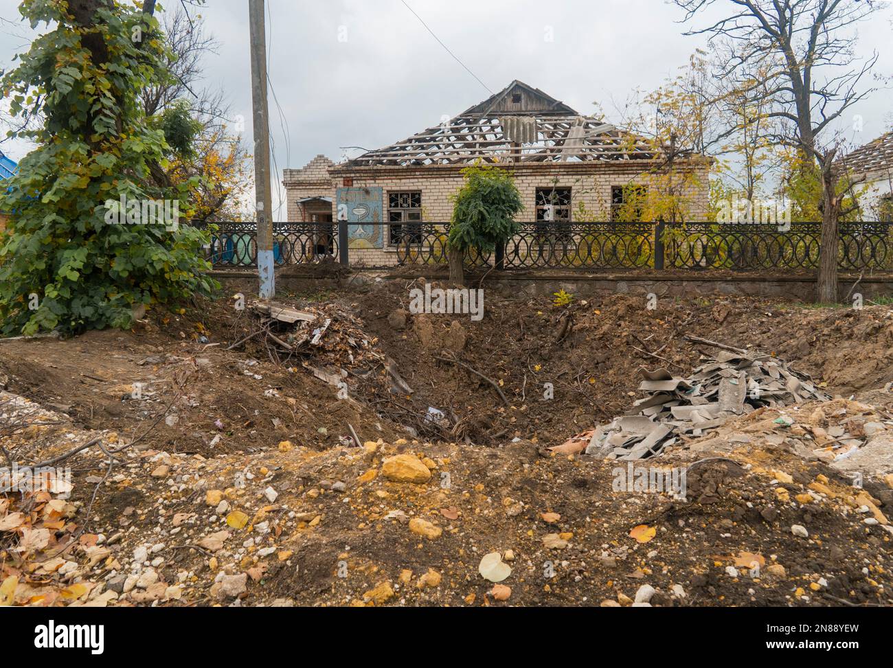Crater in the ground from a bomb explosion against the background of a ...