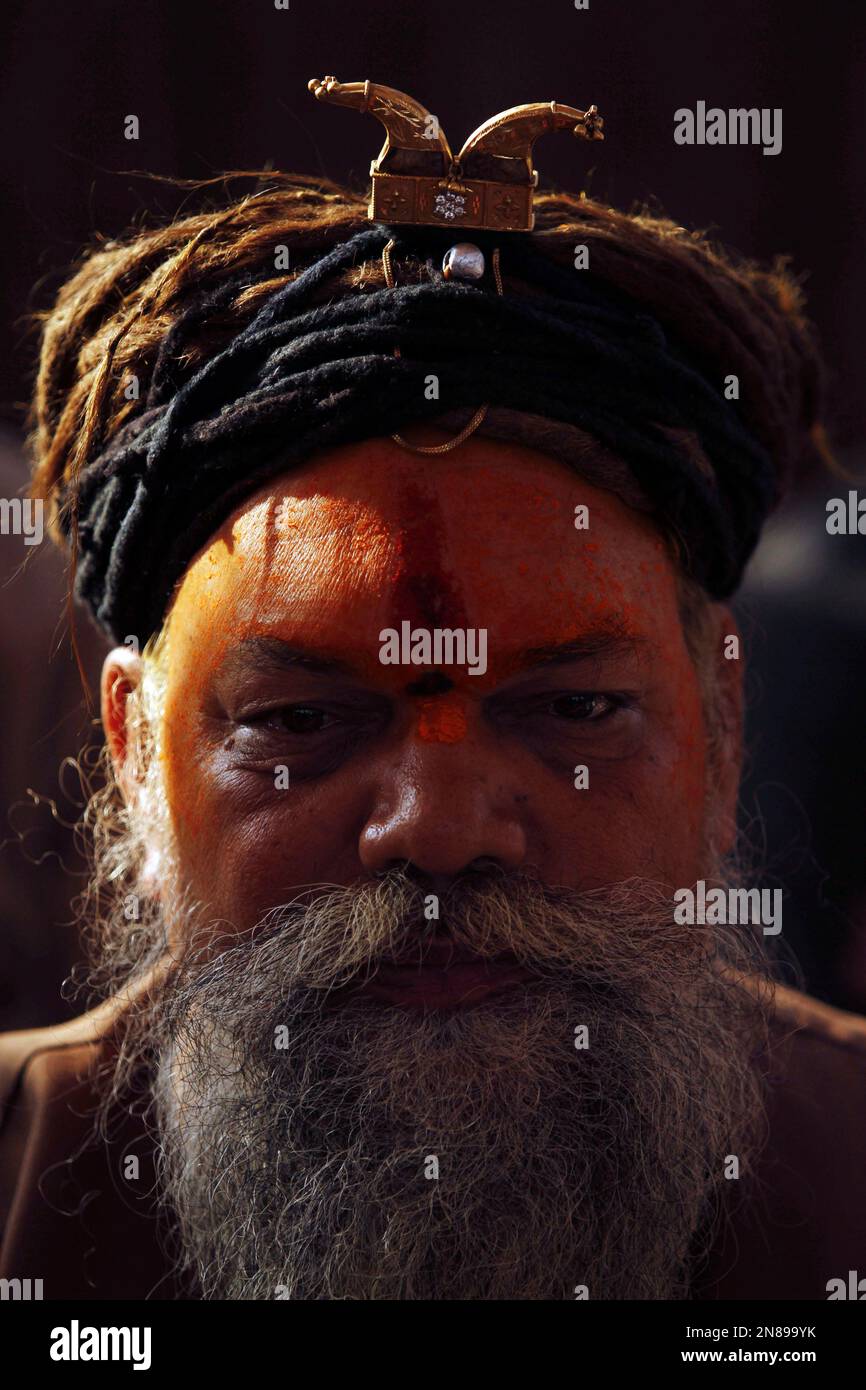 A Hindu holy man stands at Sangam, the confluence of the Ganges, and ...