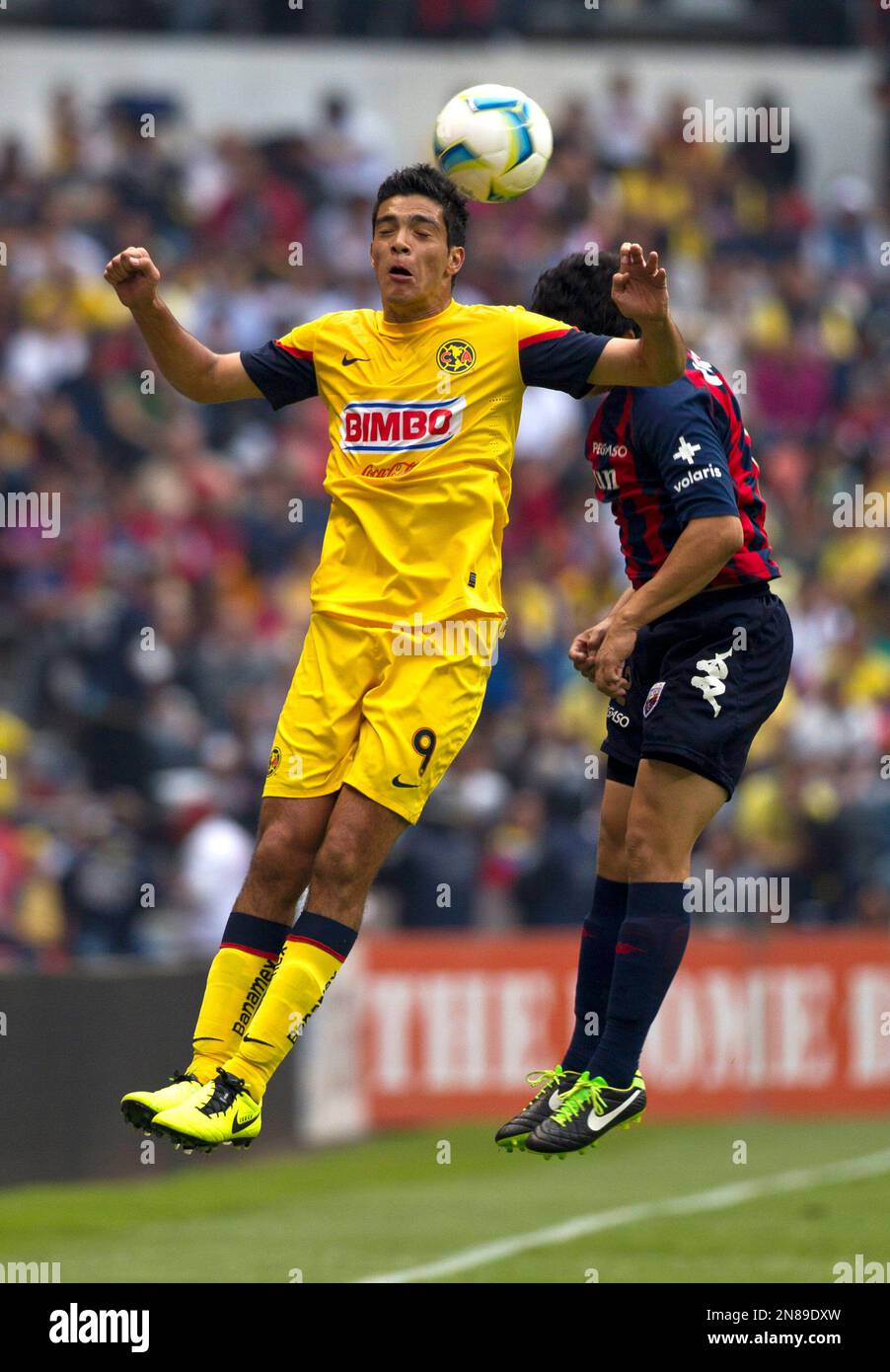 America's Raul Jimenez, left, heads for the ball under pressure from ...