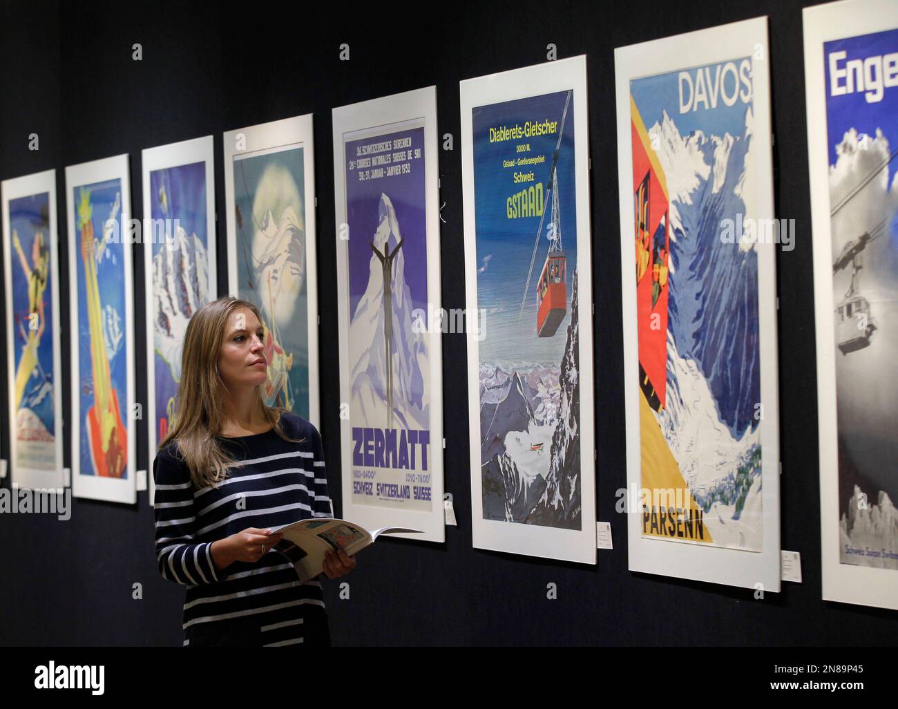 A Christie's employee poses with lithograph posters on display at the ...
