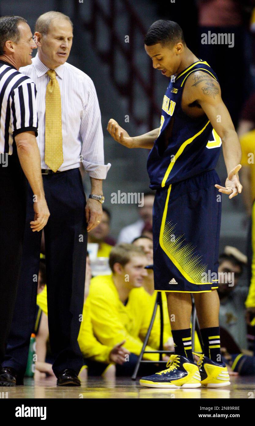 Michigan guard Trey Burke, right, shows the referee and his head coach ...