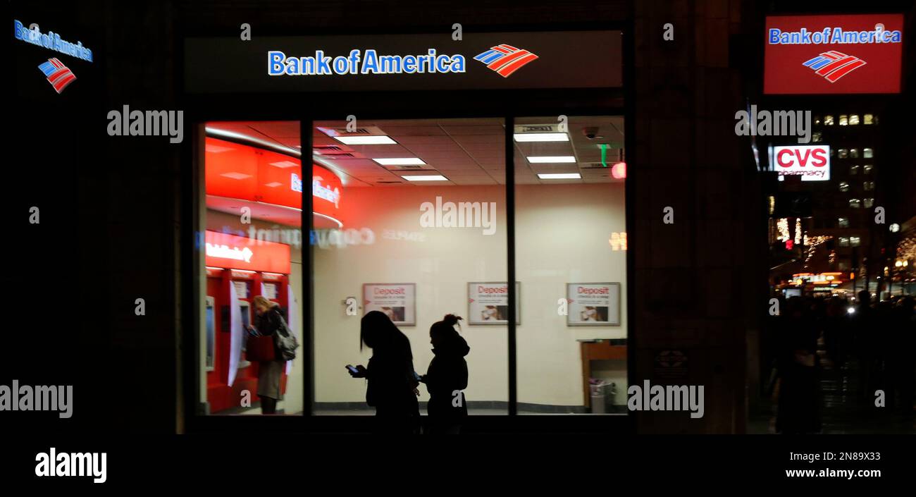 In this Thursday, Dec. 13, 2012 photo people use a Bank of America ATM ...