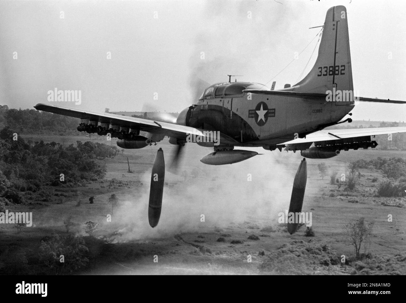 Flying low over the jungle, an A-1 Skyraider drops 500-pound bombs on a ...