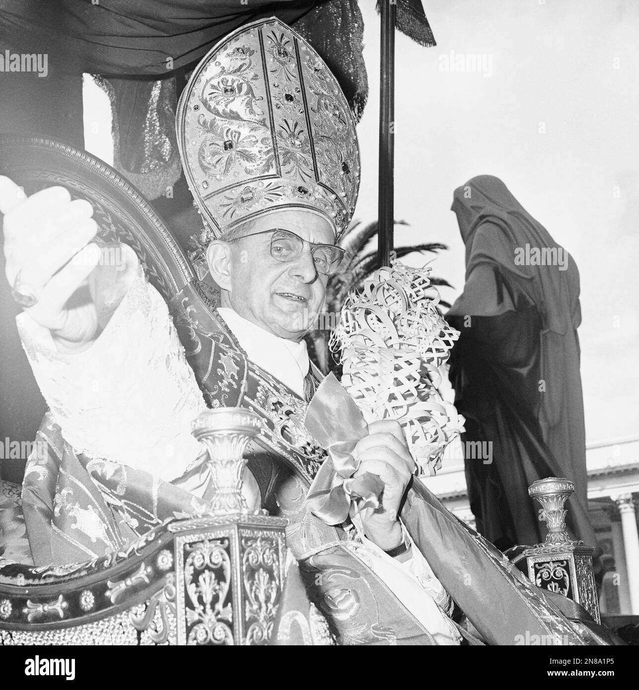 Pope Paul VI wears mitre and gestures to the crowd as he is carried on ...