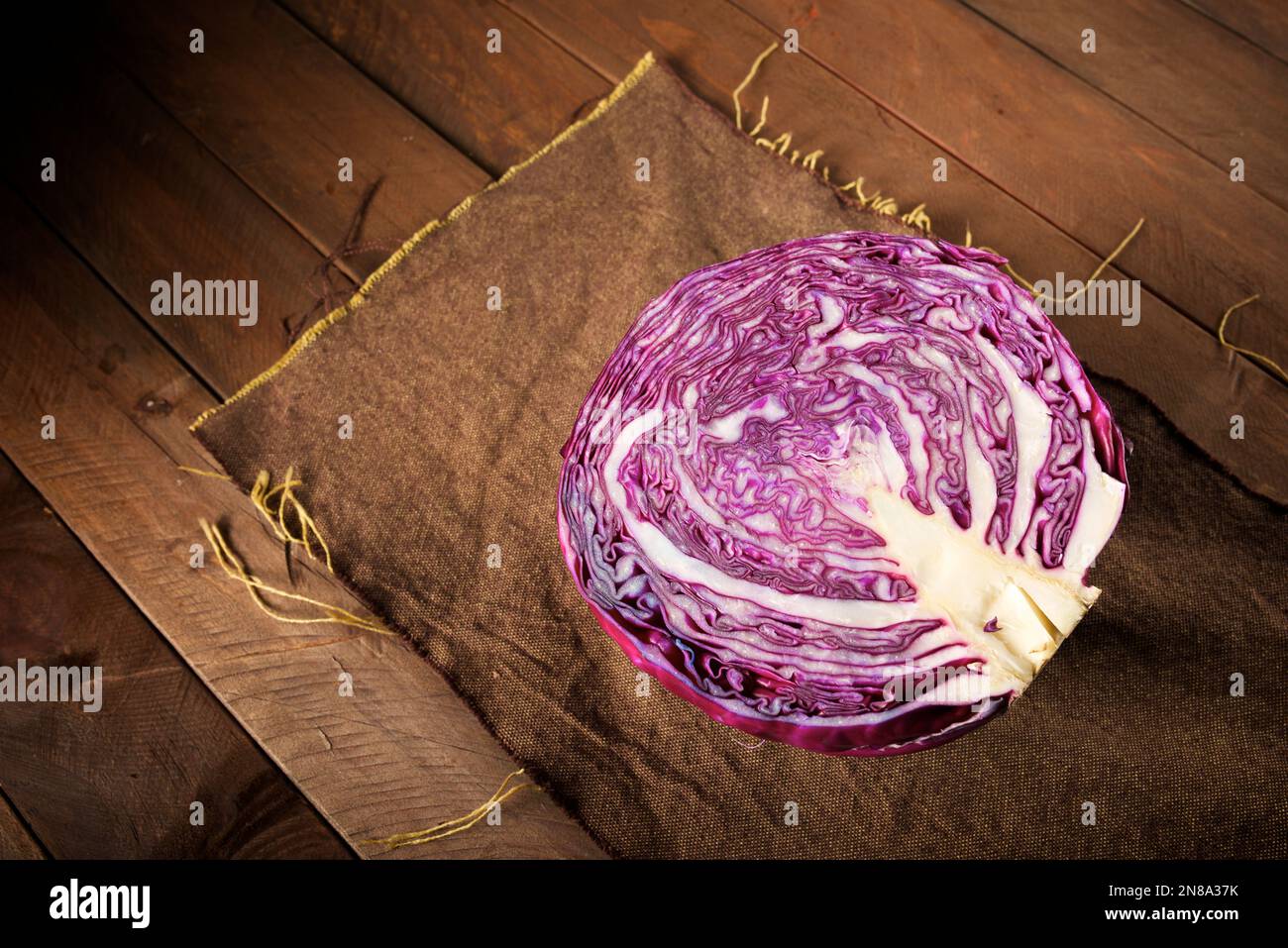Red cabbage piece on a wood table Stock Photo - Alamy