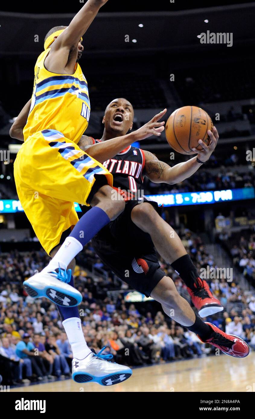 Portland Trail Blazers guard Damian Lillard (0) is fouled by Denver ...