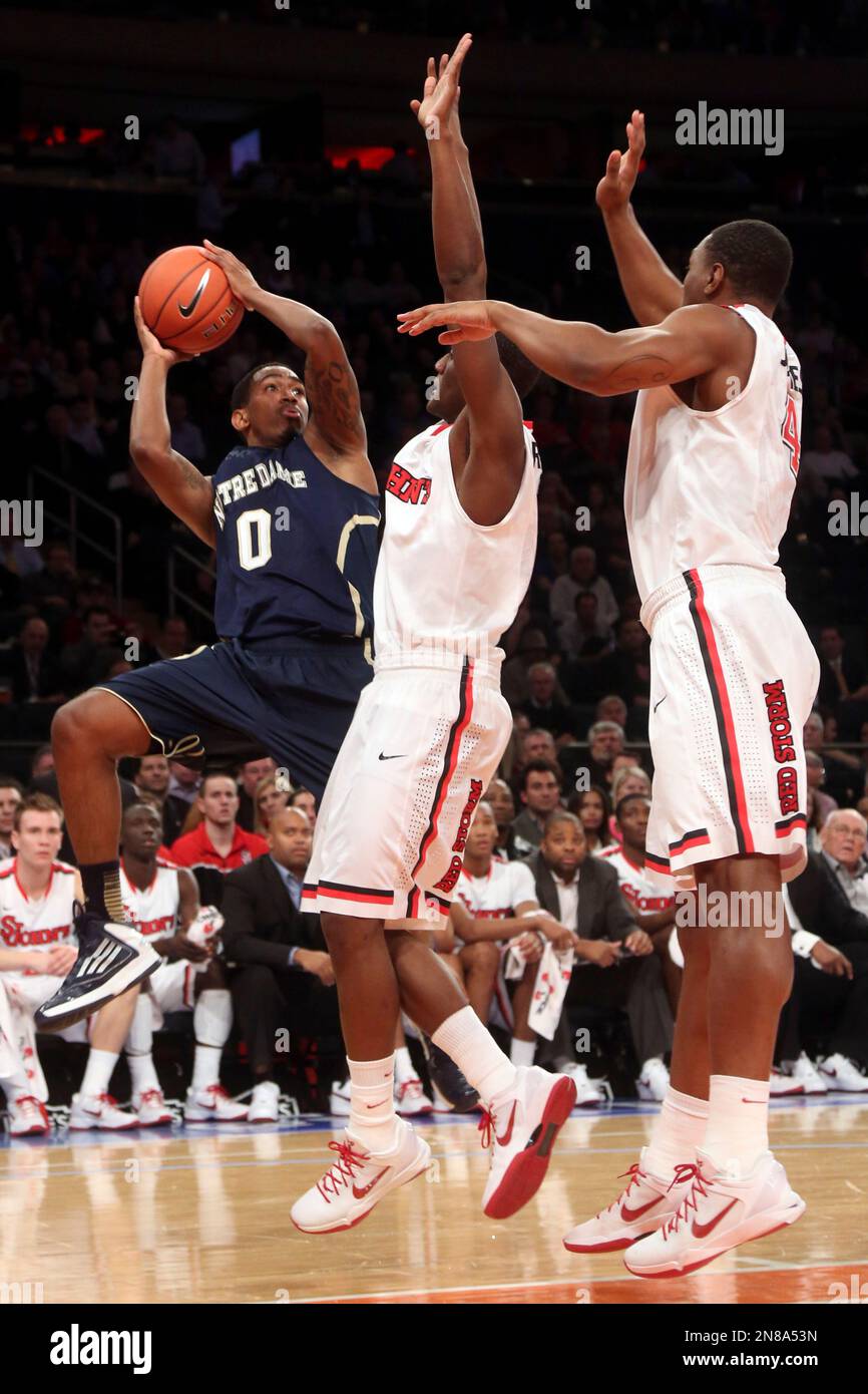 Notre Dame's Eric Atkins, left, goes up against St. John's Phil Greene ...