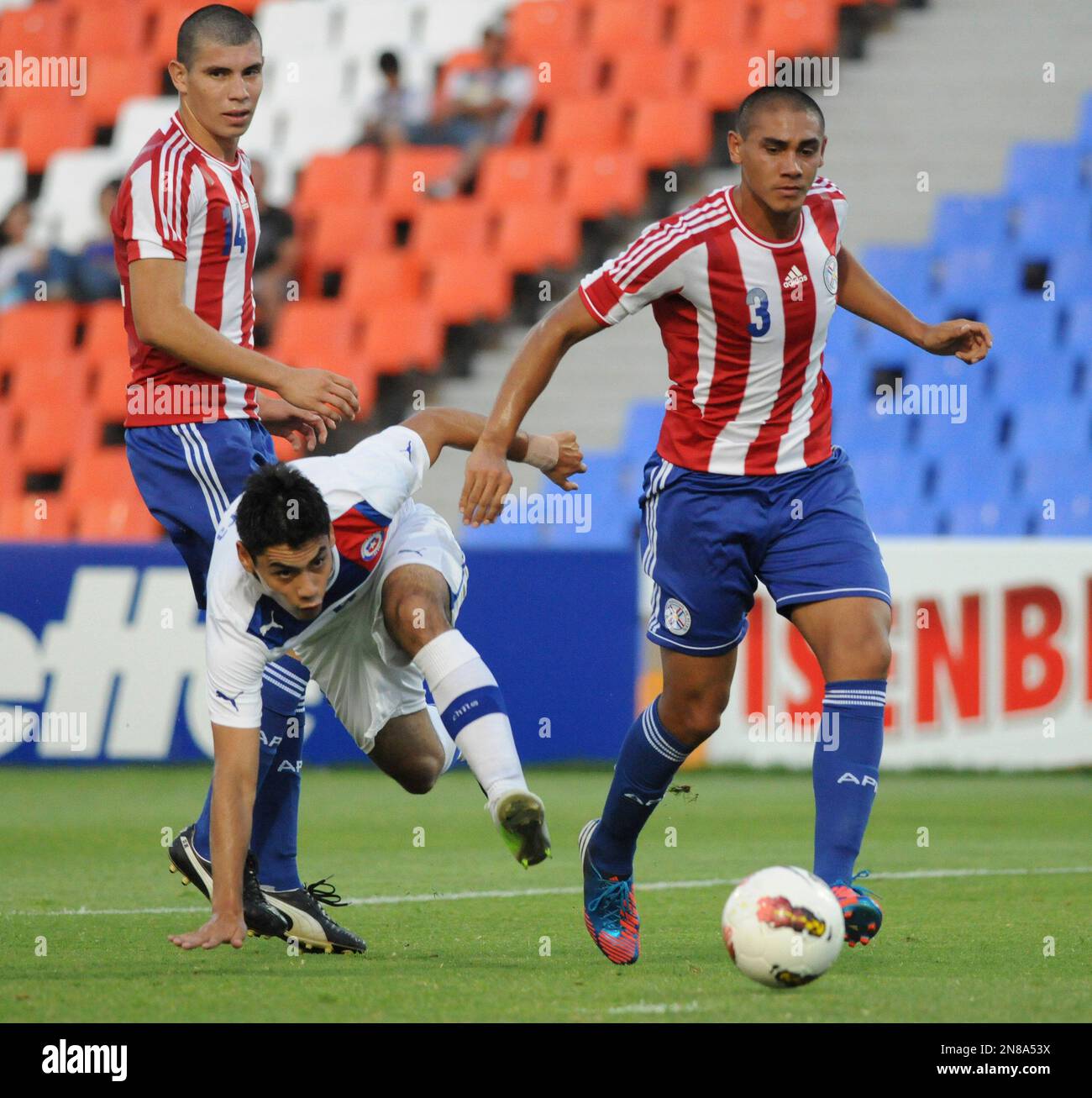 Chile's Felipe Mora, center, fights for the ball with Paraguay's ...