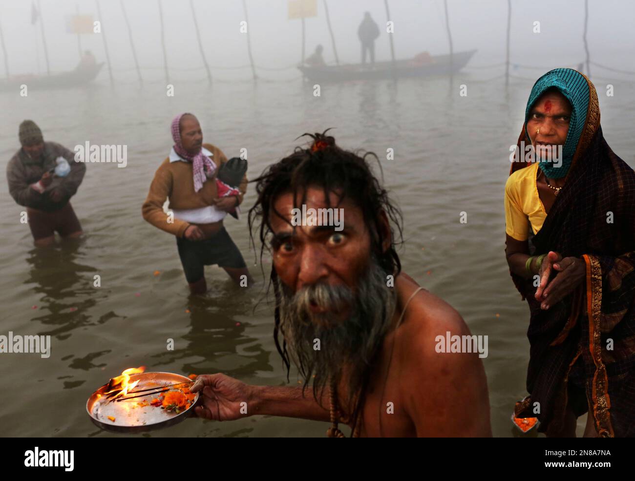 An Indian Hindu holy man performs morning prayers for devotees at ...