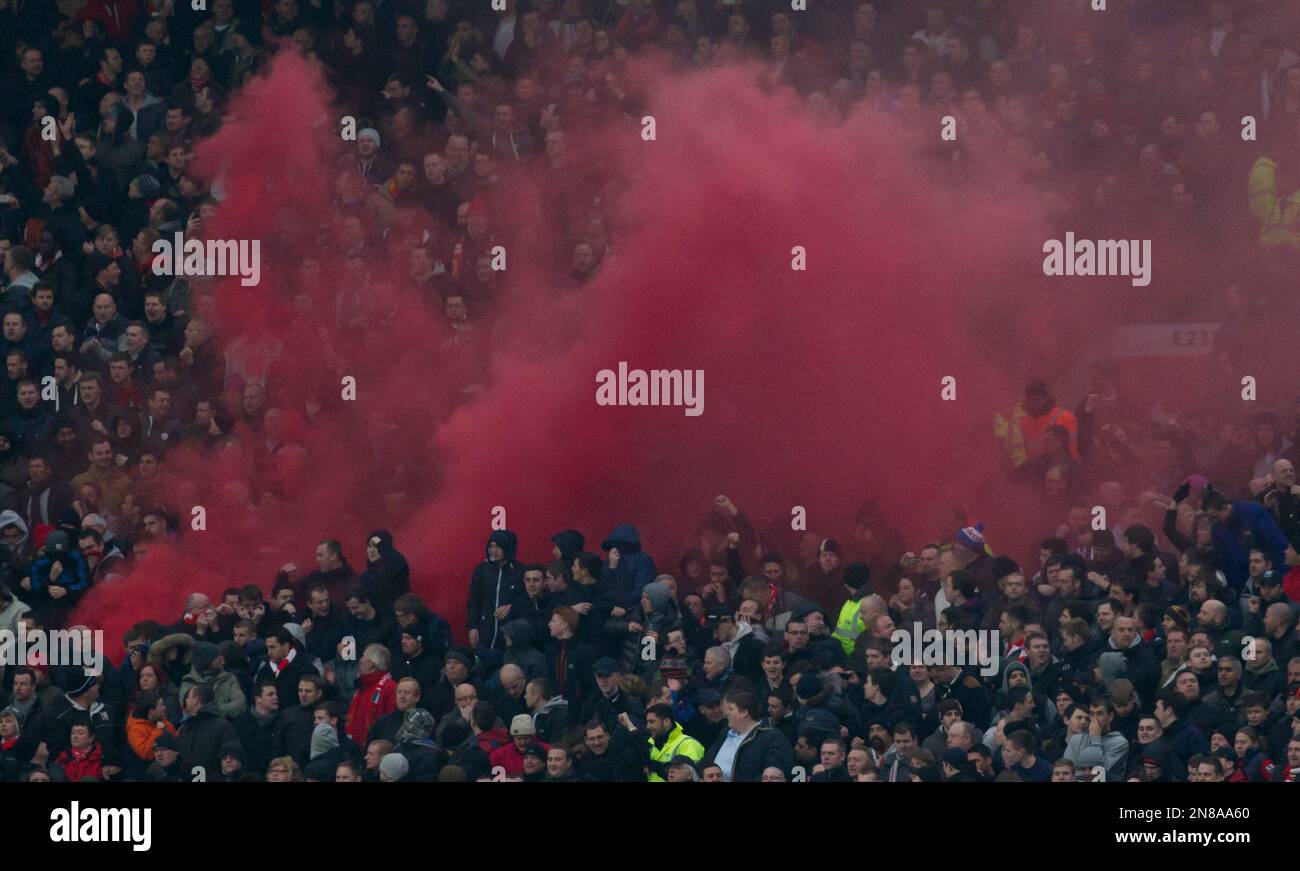 Liverpool supporters stand in the smoke from a flare during their team ...