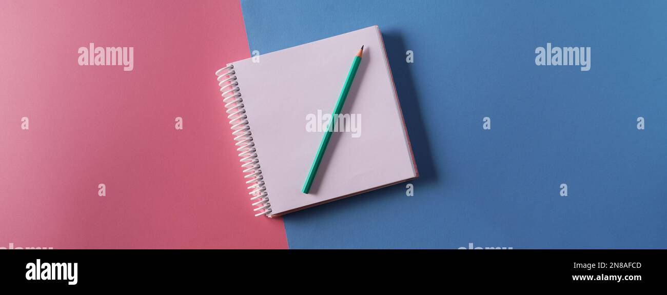 Mockup, banner. An empty A4 notebook on a pink and blue paper ...