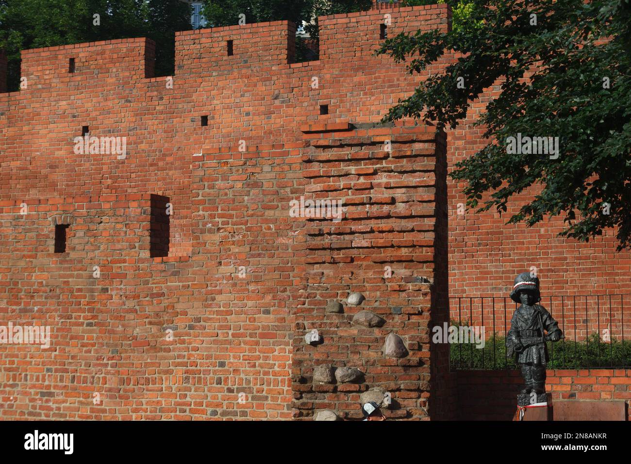 An old brick wall behind Maly Powstaniec statue in commemoration of the ...