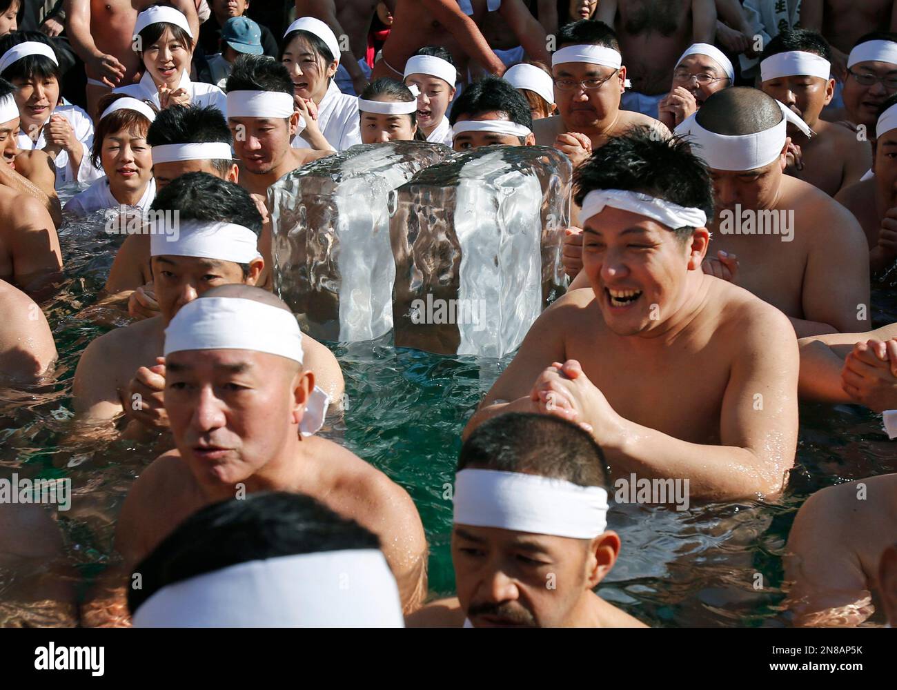 Japanese physical fitness enthusiasts pray while dipping in icy water ...