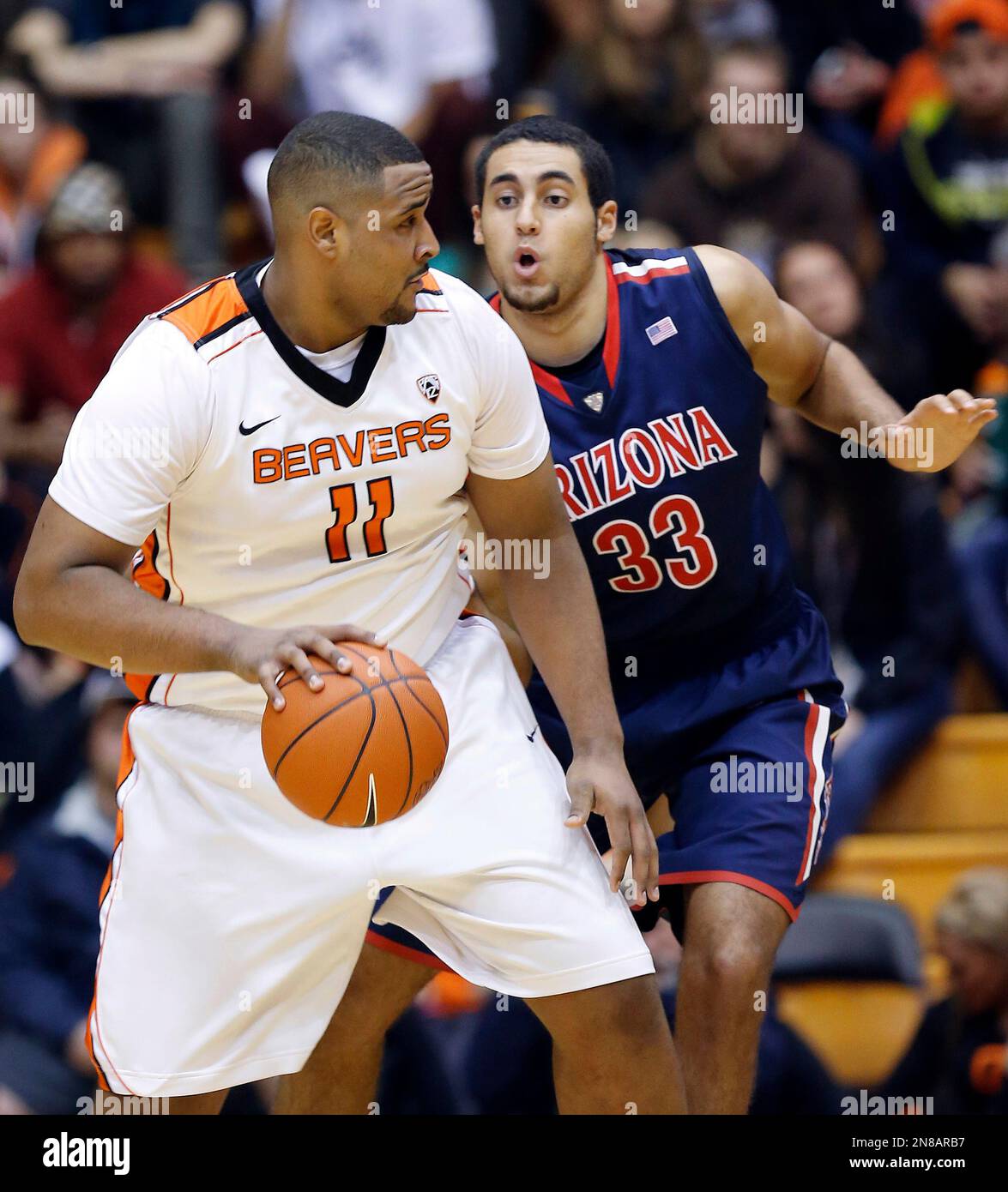 Oregon State center Joe Burton, left, drives against Arizona forward ...