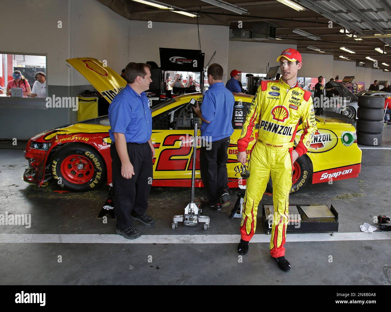 Joey Logano, right, walks away from his car in the garage as his crew ...