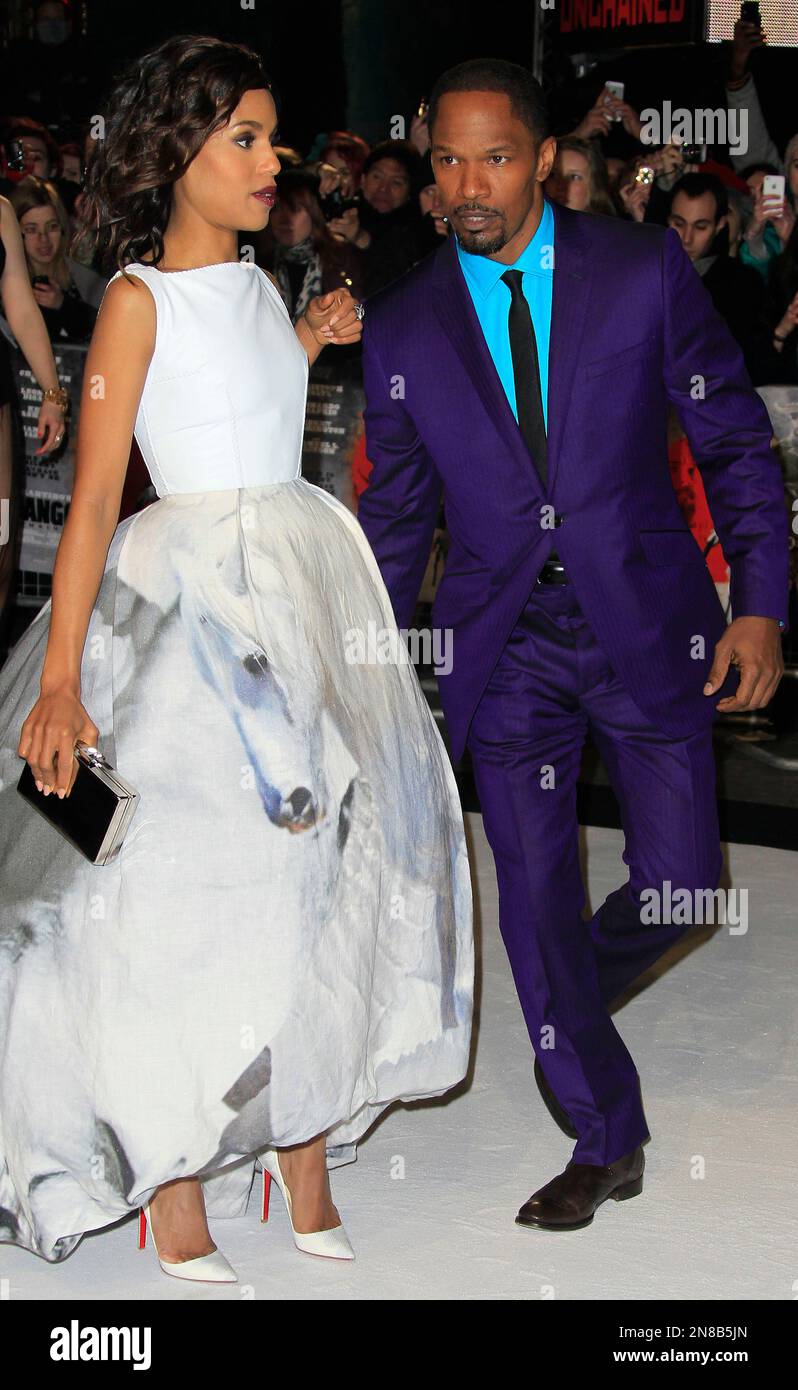 Jamie Foxx holds the dress of Kerry Washington as they arrive for the ...