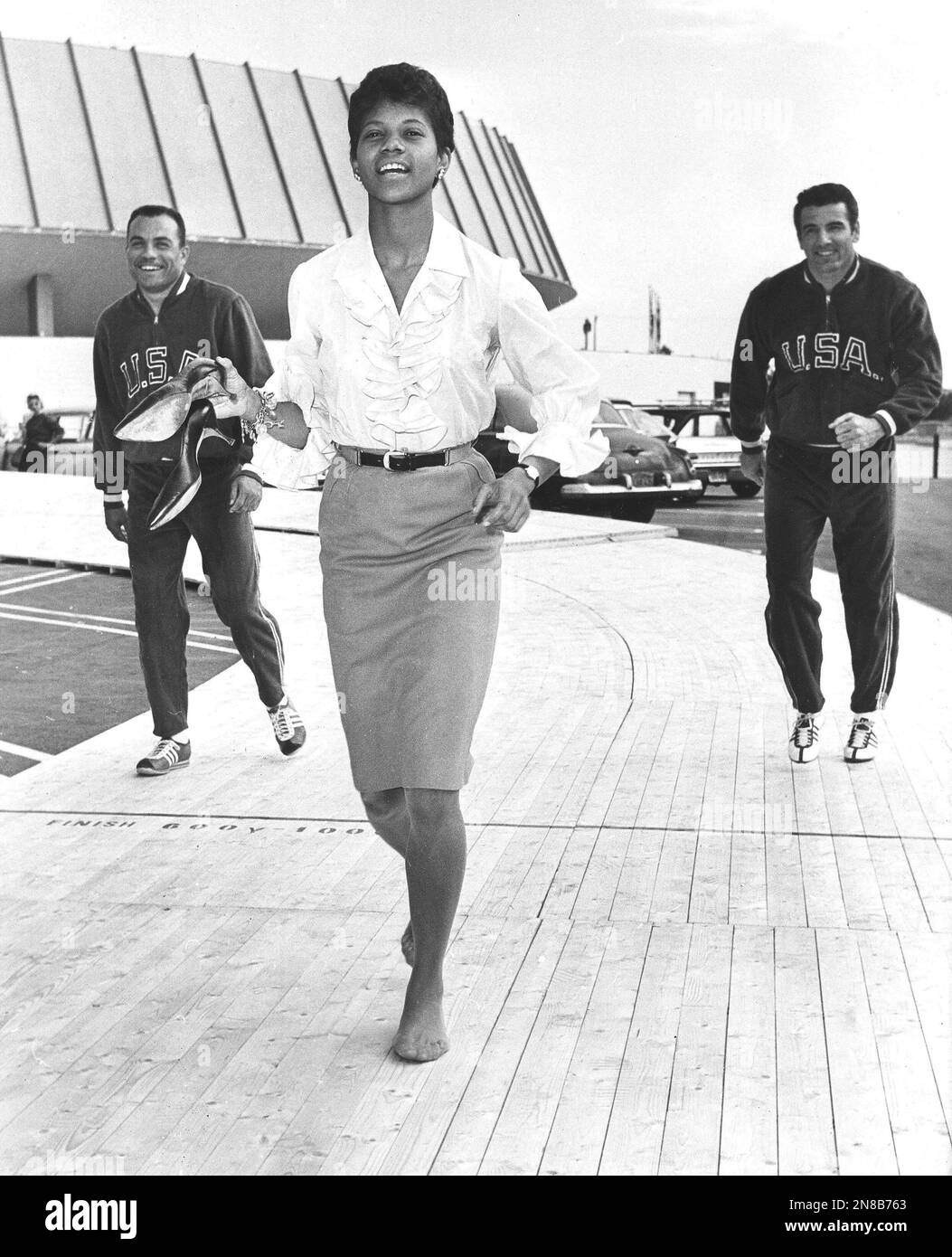Wilma Rudolph who won three gold medals in the Rome Olympics, holds her ...