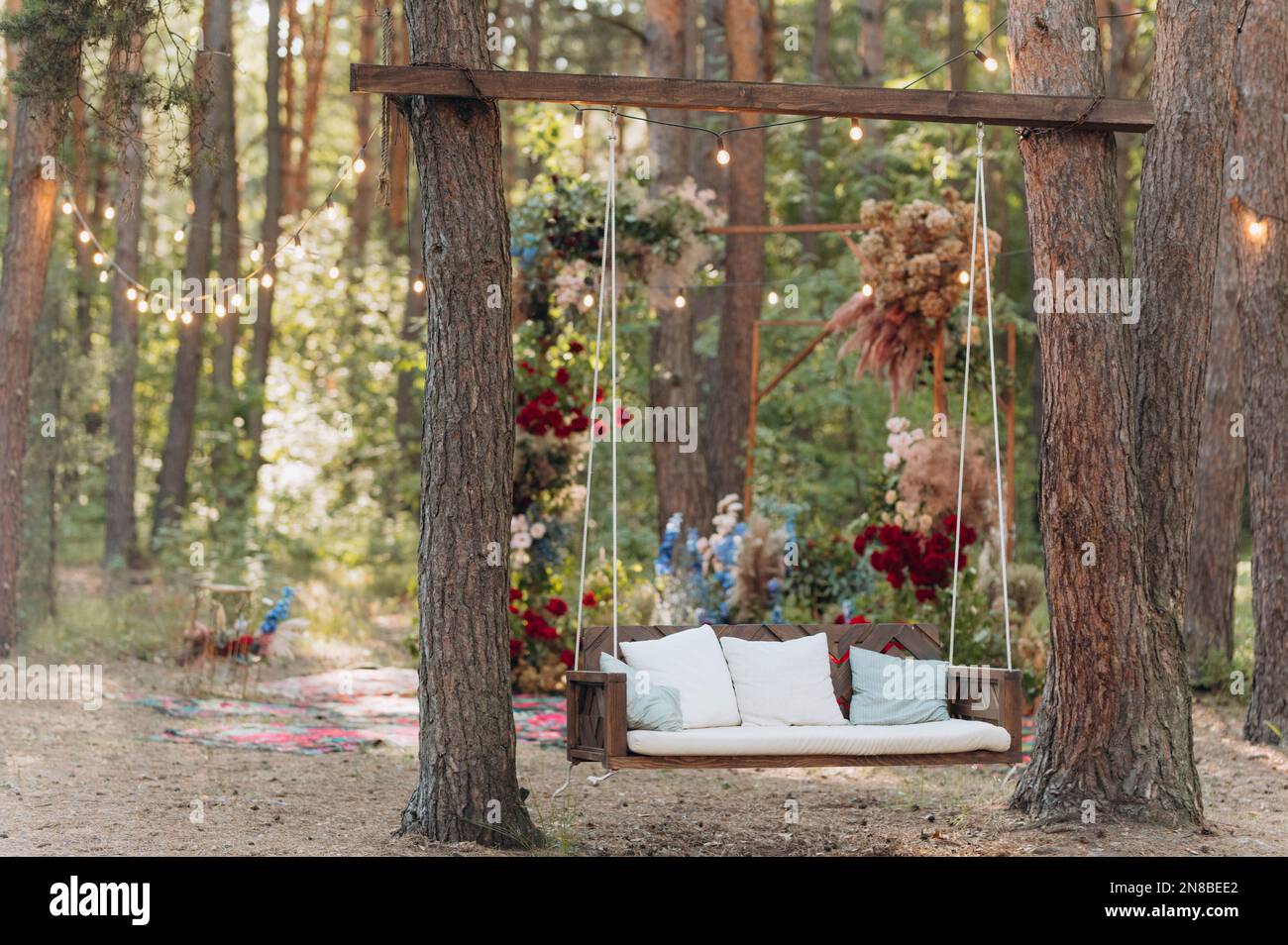 Wooden summer swing in a pine forest. Summer vacation in the country ...