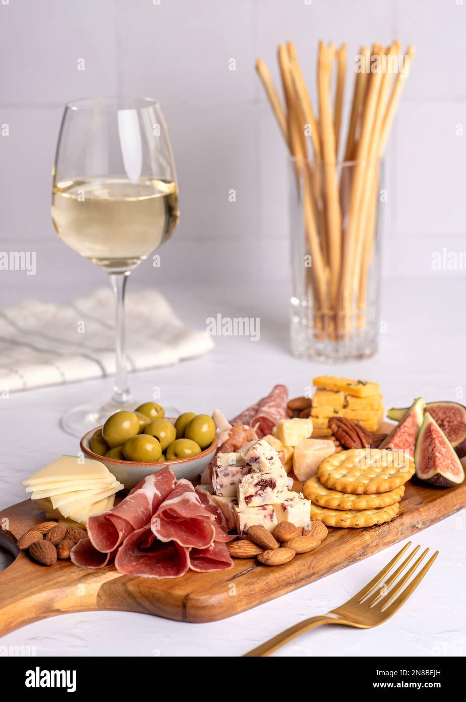 Food photography of appetizer, white wine, salami, grissini, cracker ...