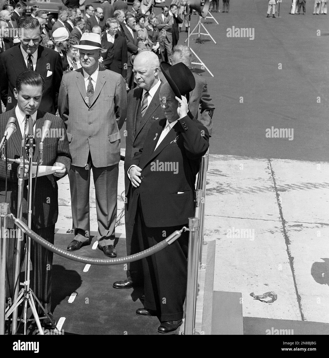 Soviet Premier Nikita Khrushchev uses his hat to shade his eyes from ...