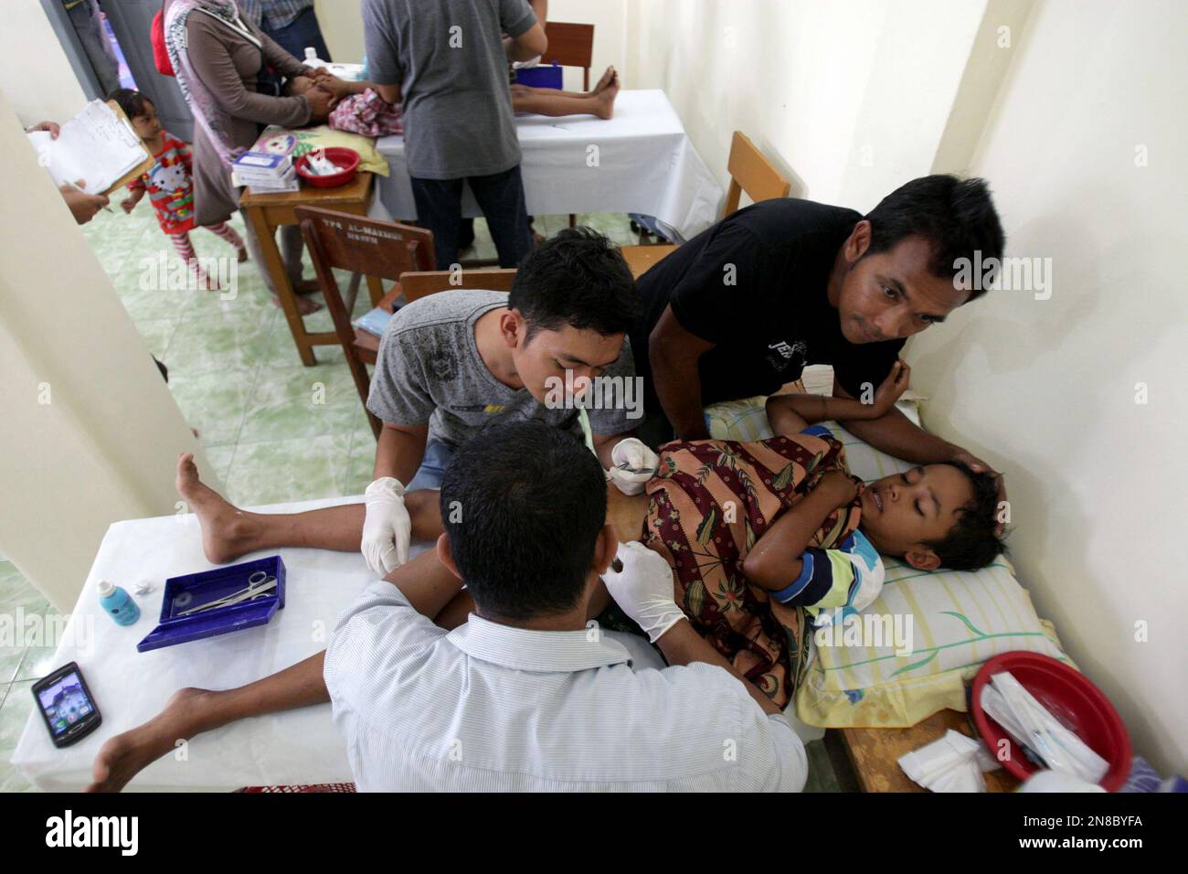 Paramedics perform circumcision to a boy during a charge-free mass circumcision in Aceh Besar ...