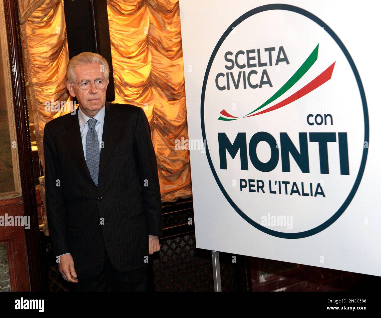 Italian Premier Mario Monti poses next to the logo of his new party in ...