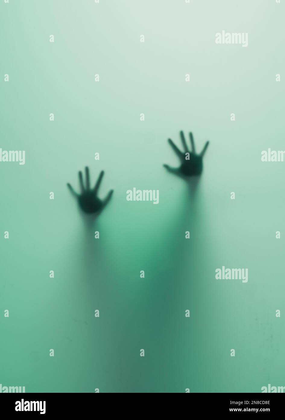 A vertical shot of blurred human hands behind a green glass Stock Photo ...
