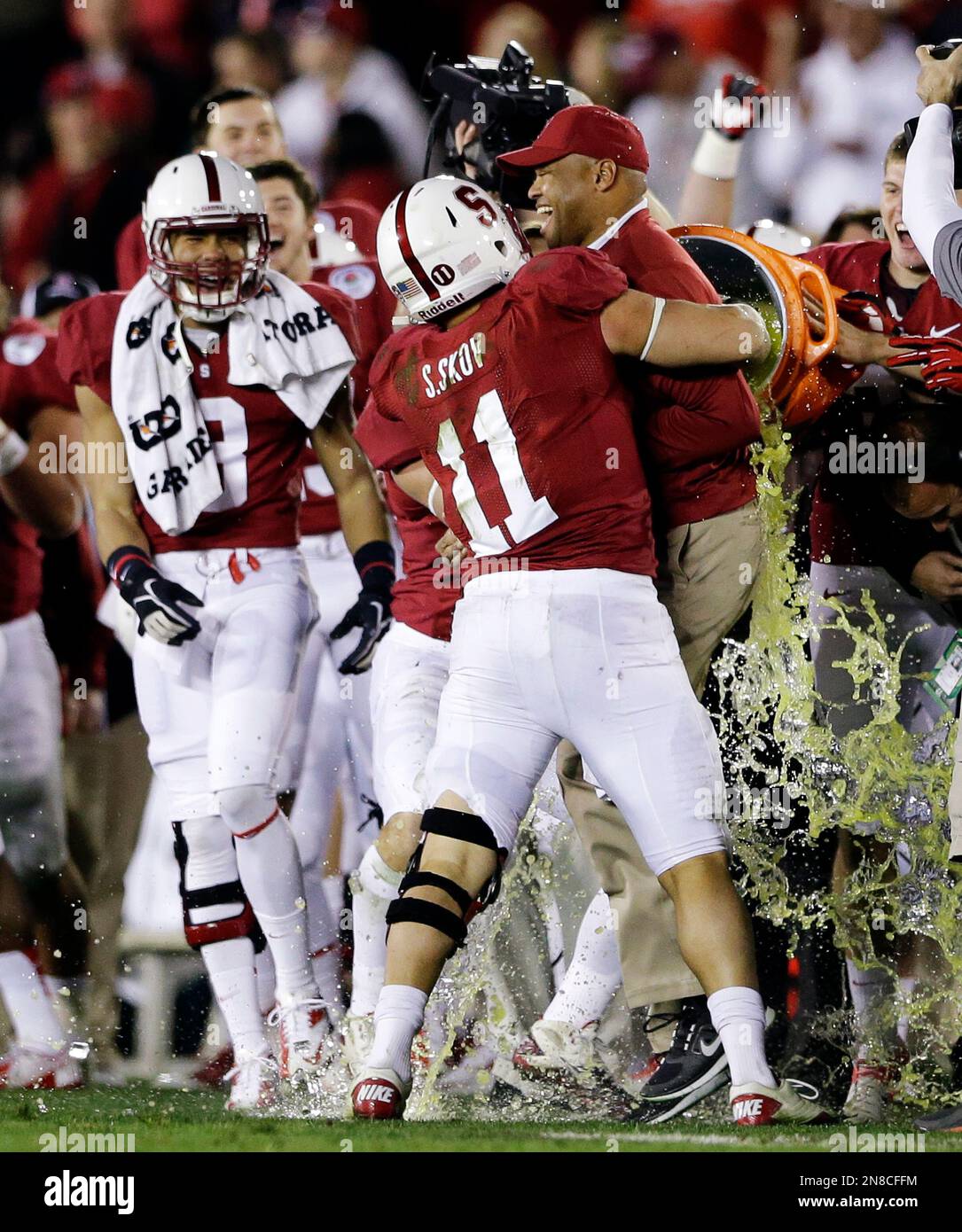 Stanford head coach David Shaw is hugged by linebacker Shayne Skov (11 ...