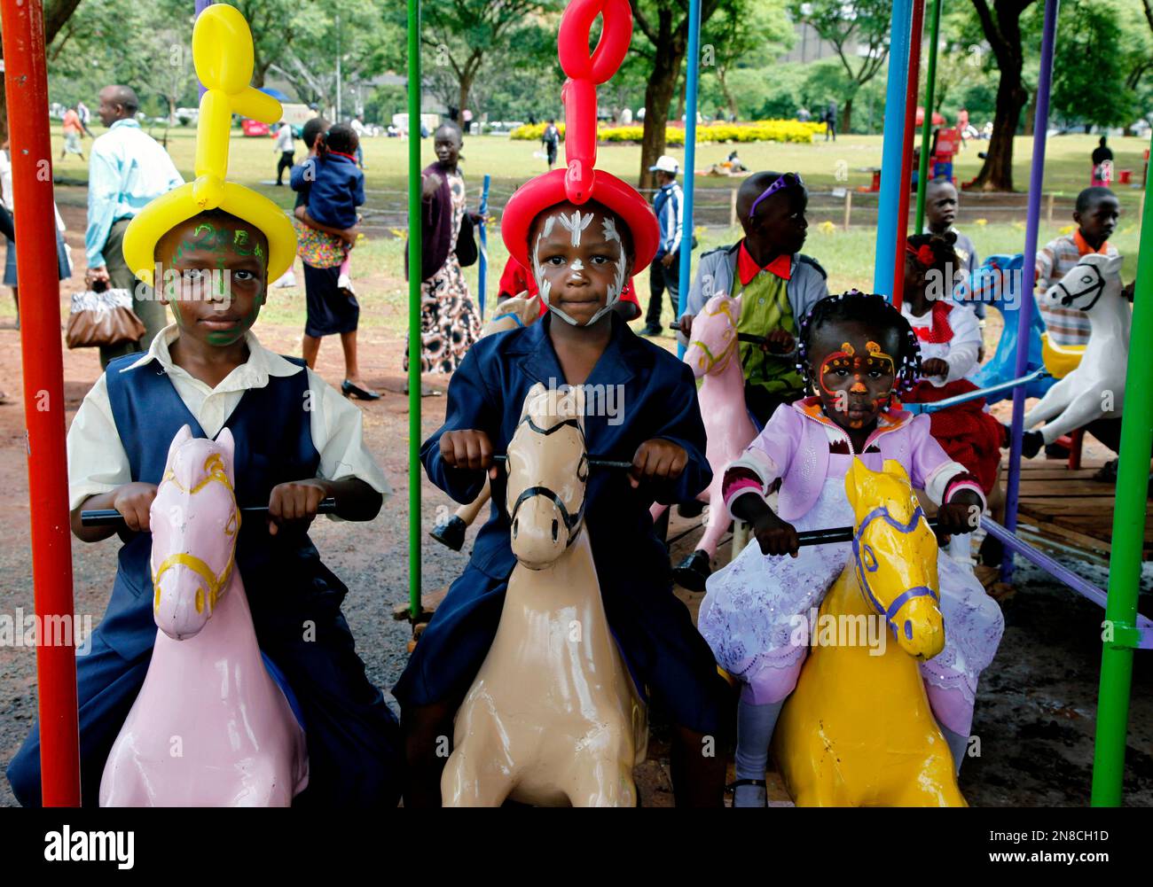 Kenyan children ride a carousel as families gather to celebrate the new ...