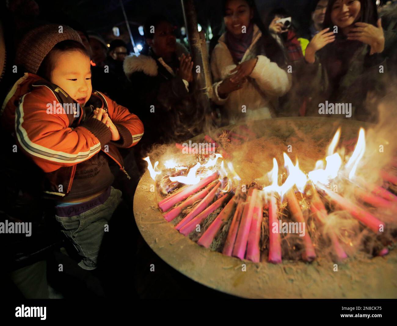A boy prays around a fire believed to invoke divine help during their ...