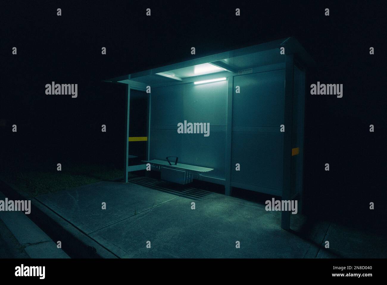 A cinematic shot of an empty bus stop at night with a light on Stock ...