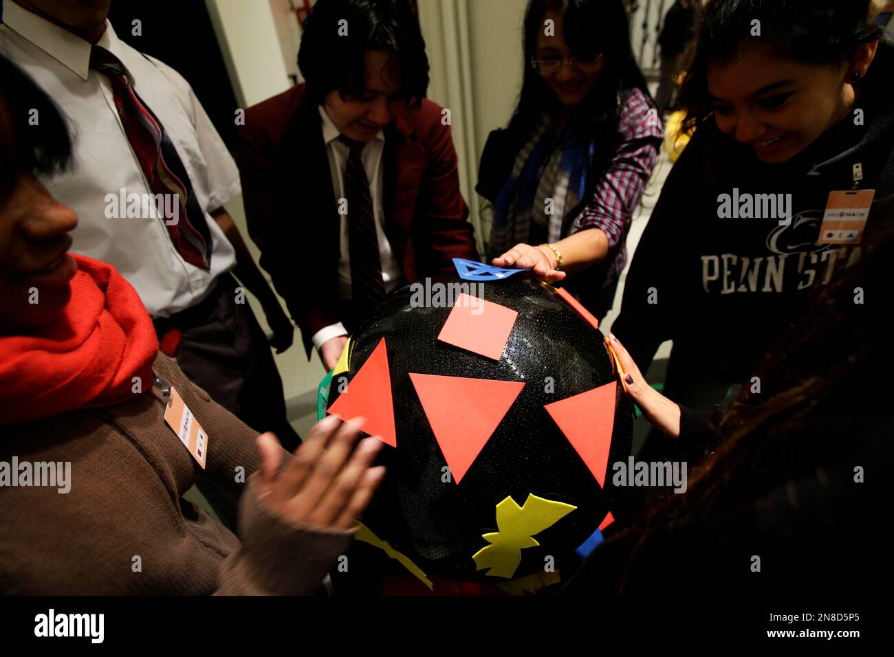 Students visiting the new National Museum of Mathematics put shapes on ...