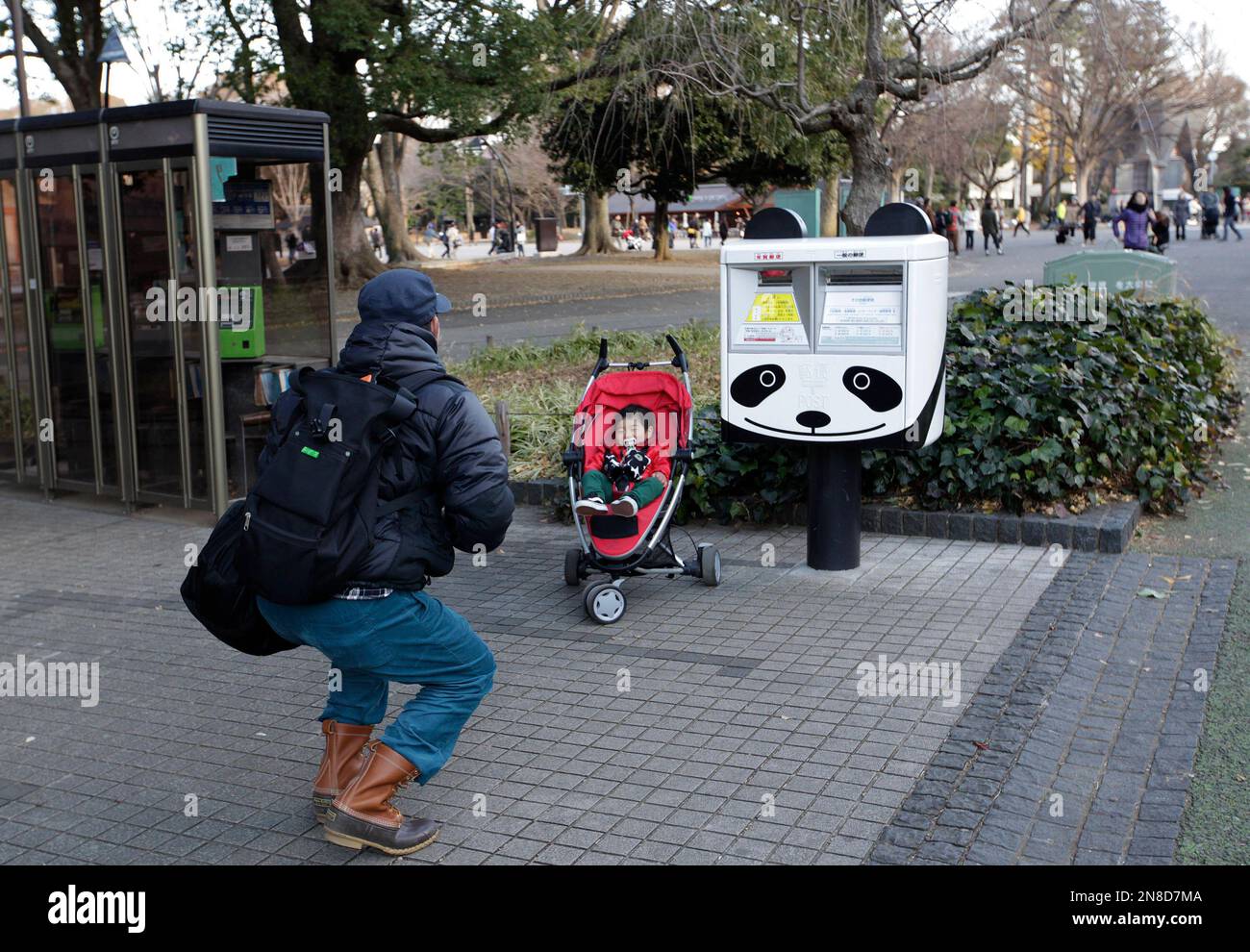 A man takes pictures of his child with a mailbox decorated as a panda ...