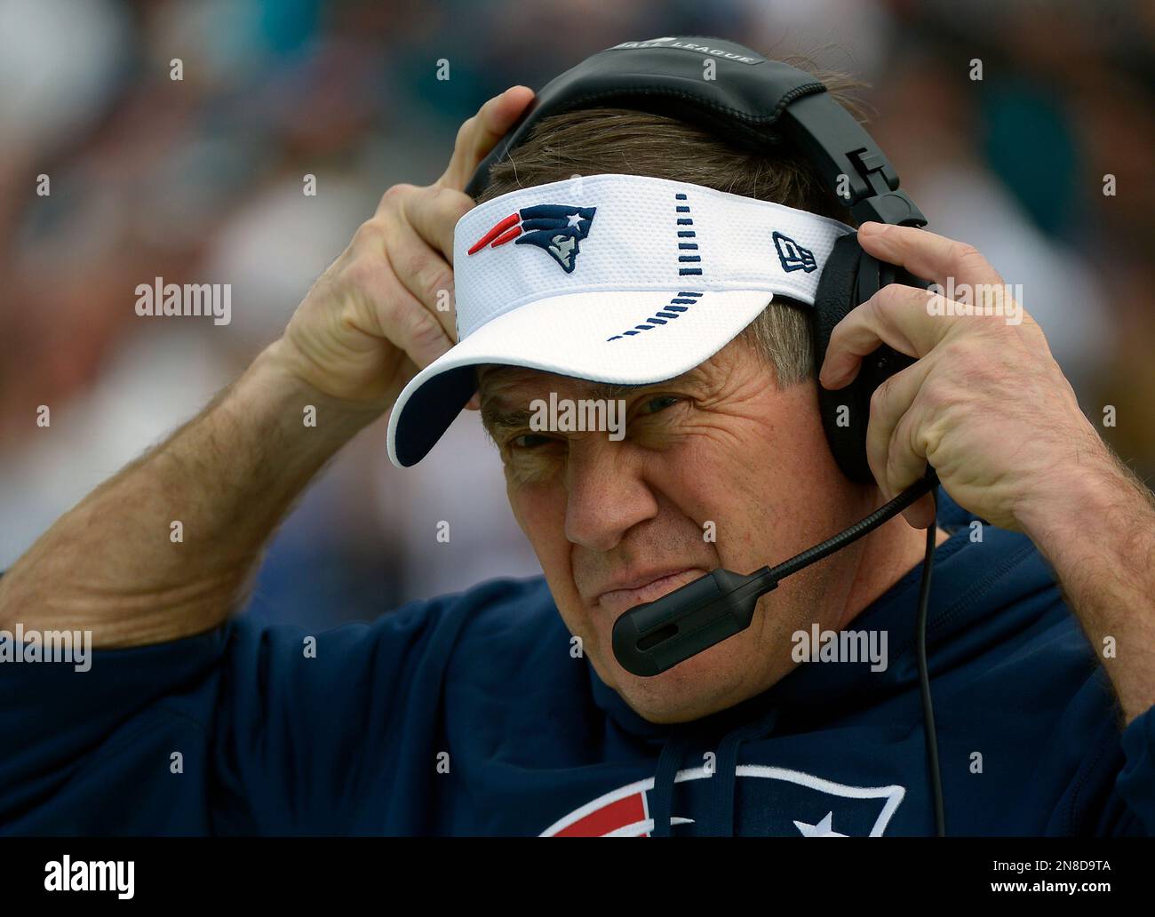 New England Patriots head coach Bill Belichick adjusts his headset ...