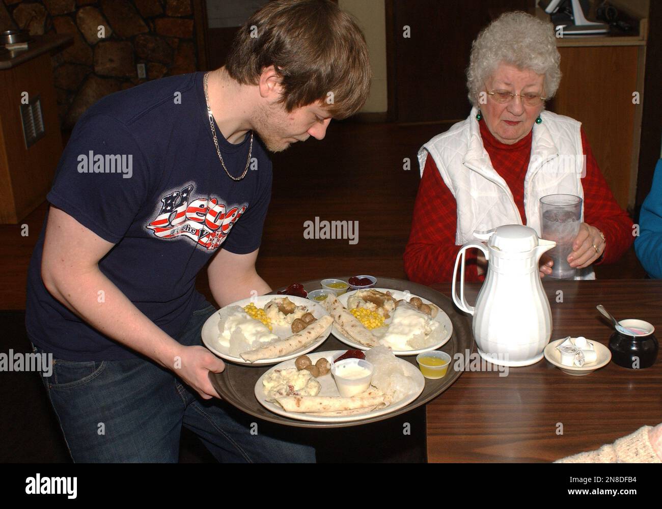 In this Dec. 20, 2012 photo, Ryan Bosma serves lutefisk to Marian ...