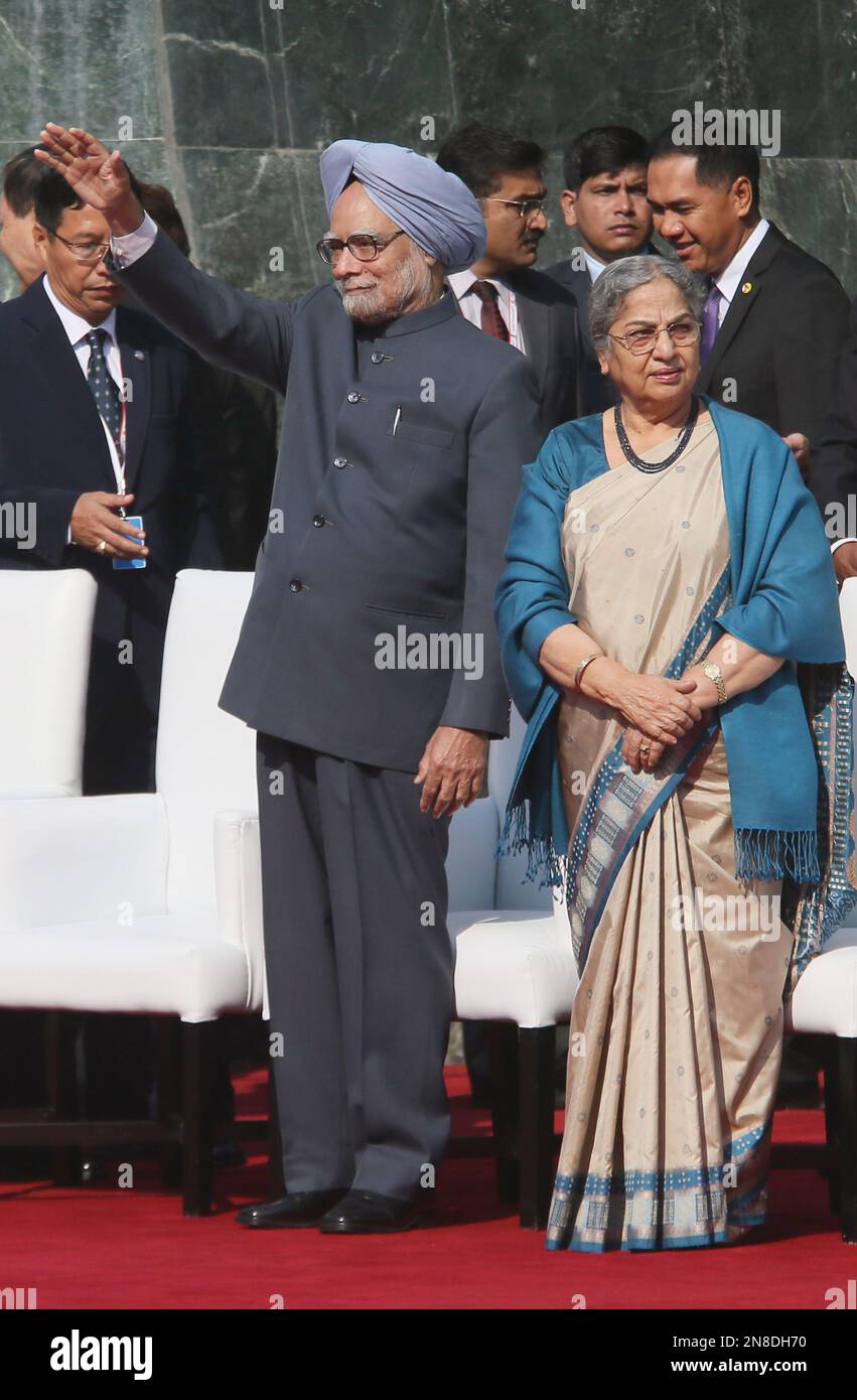 Indian Prime Minister Manmohan Singh with his wife Gursharan Kaur waves ...