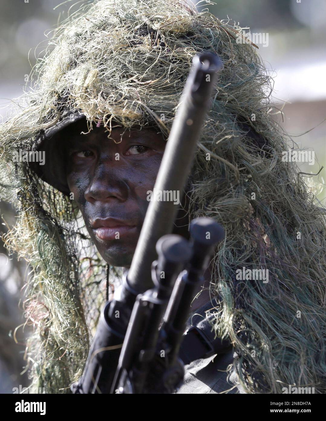 A member of the Philippine Army Sniper Unit prepares to take their formation at the 77th ...