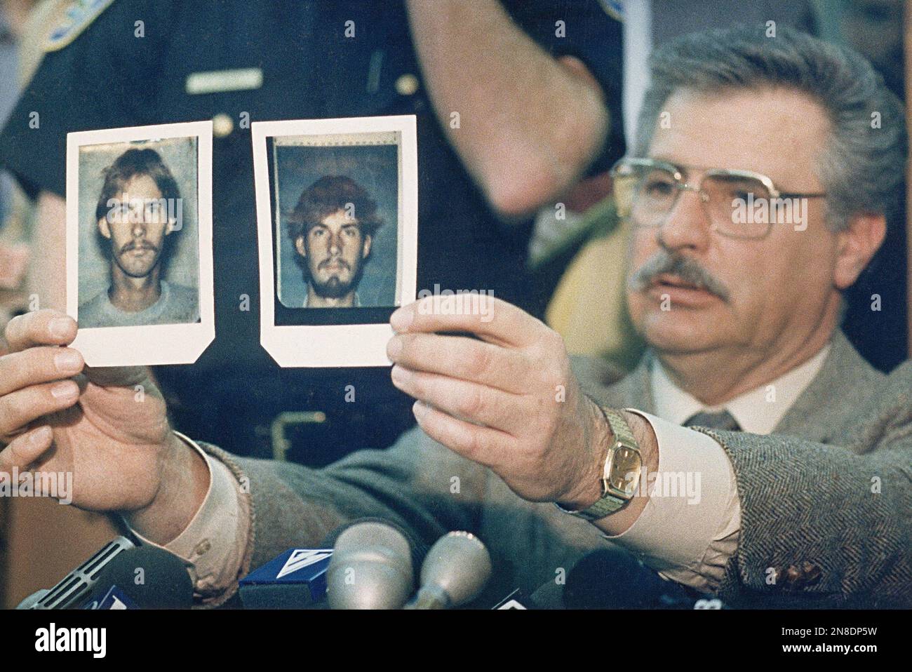 Stockton police homicide Captain Dennis Perry holds up two recent ...