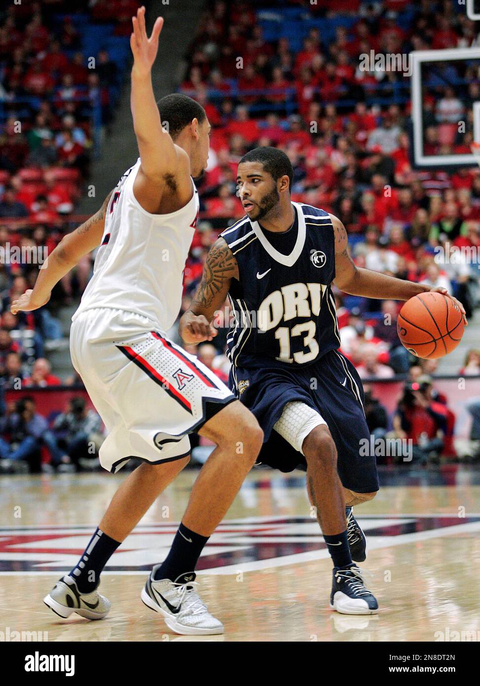 Oral Roberts' Warren Niles (13) dribbles around Arizona's Grant Jerrett ...