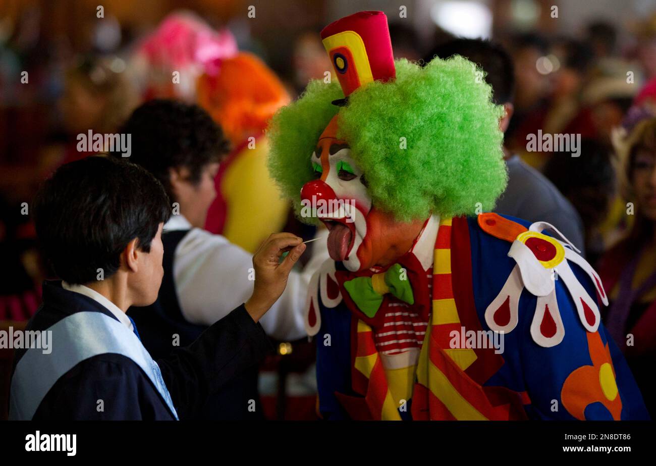 A clown receives communion during a mass at the Basilica of Guadalupe ...